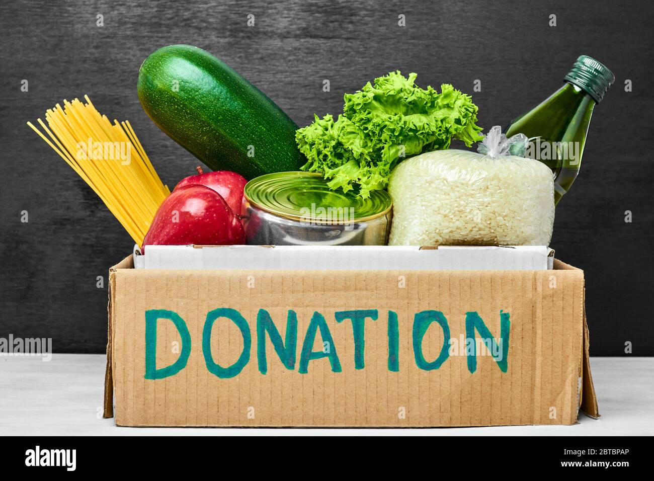 Donation cardboard box with food on a black background. Charity concept ...