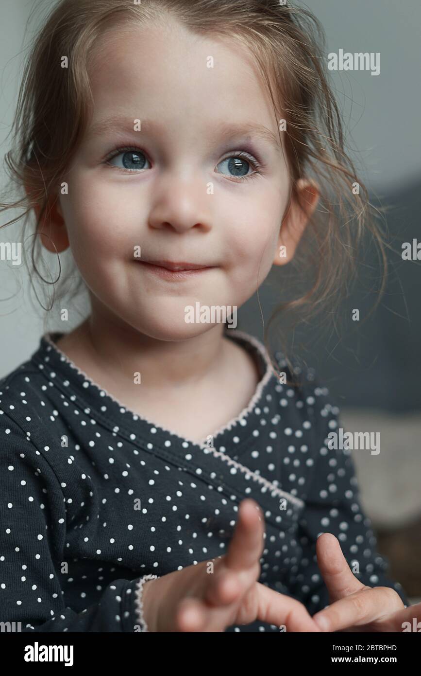 Beautiful small girl plays with cosmetics at home Stock Photo - Alamy
