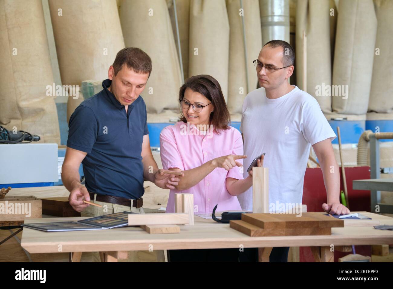 Team of woodworking workshop workers are discussing Stock Photo - Alamy