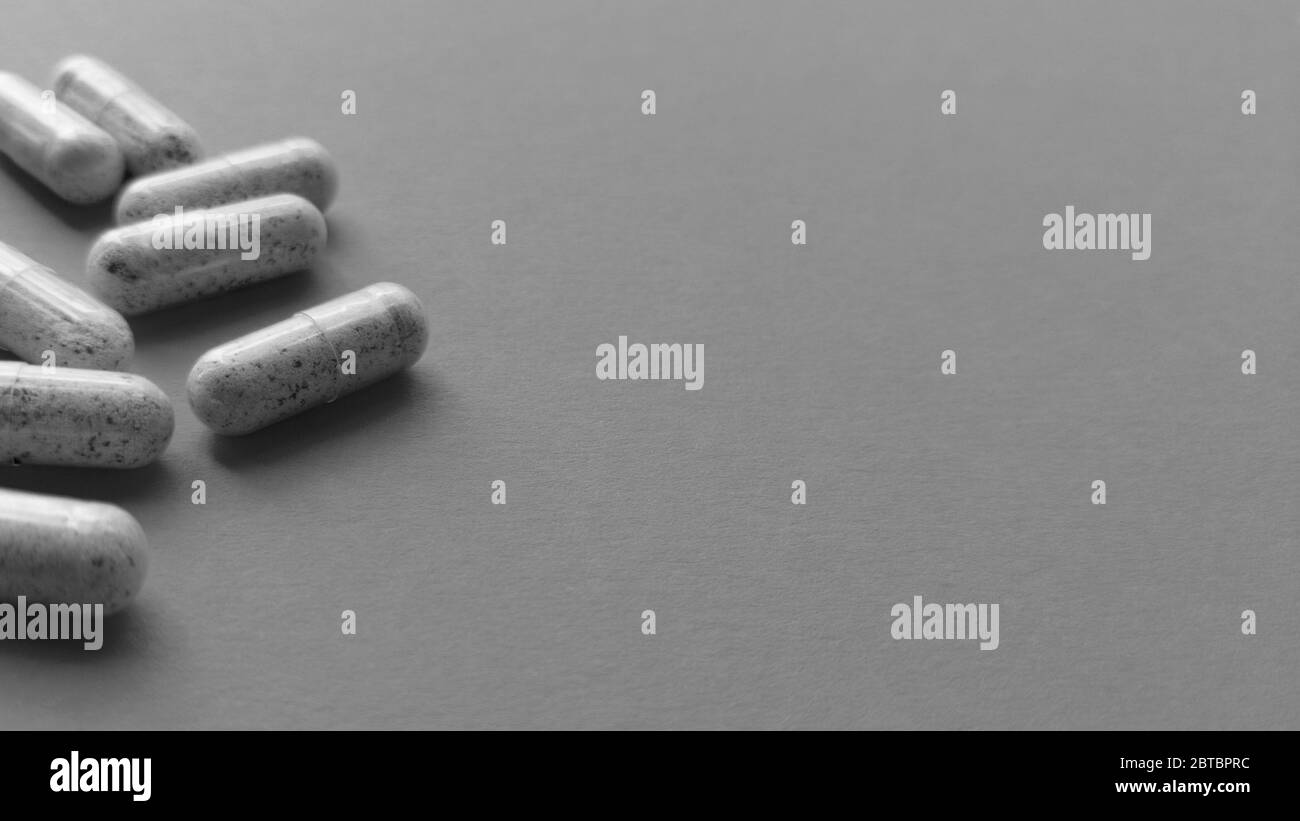 Pill capsules on grey background. Simple flat lay with pastel texture ...