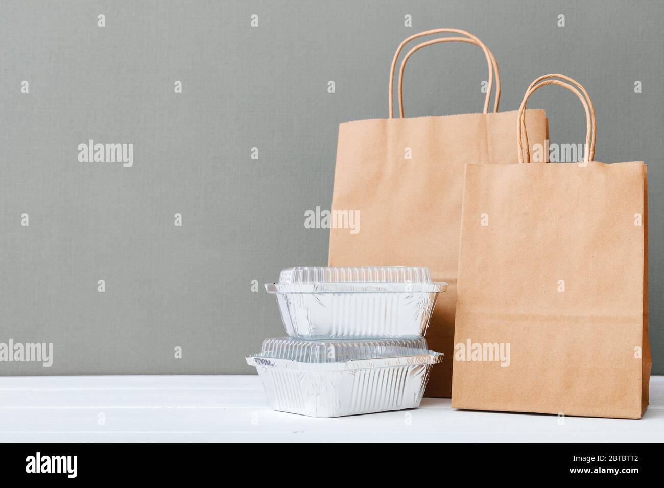 Paper bags and food containers on white table gray background. Food ...