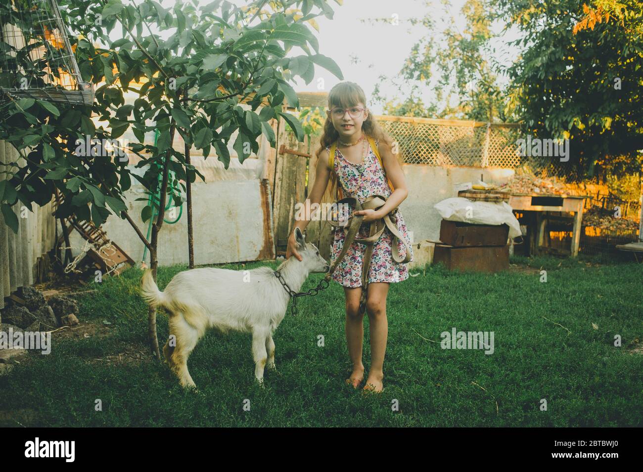 girl with baby goat on farm outdoors. Love and care. Village animals ...