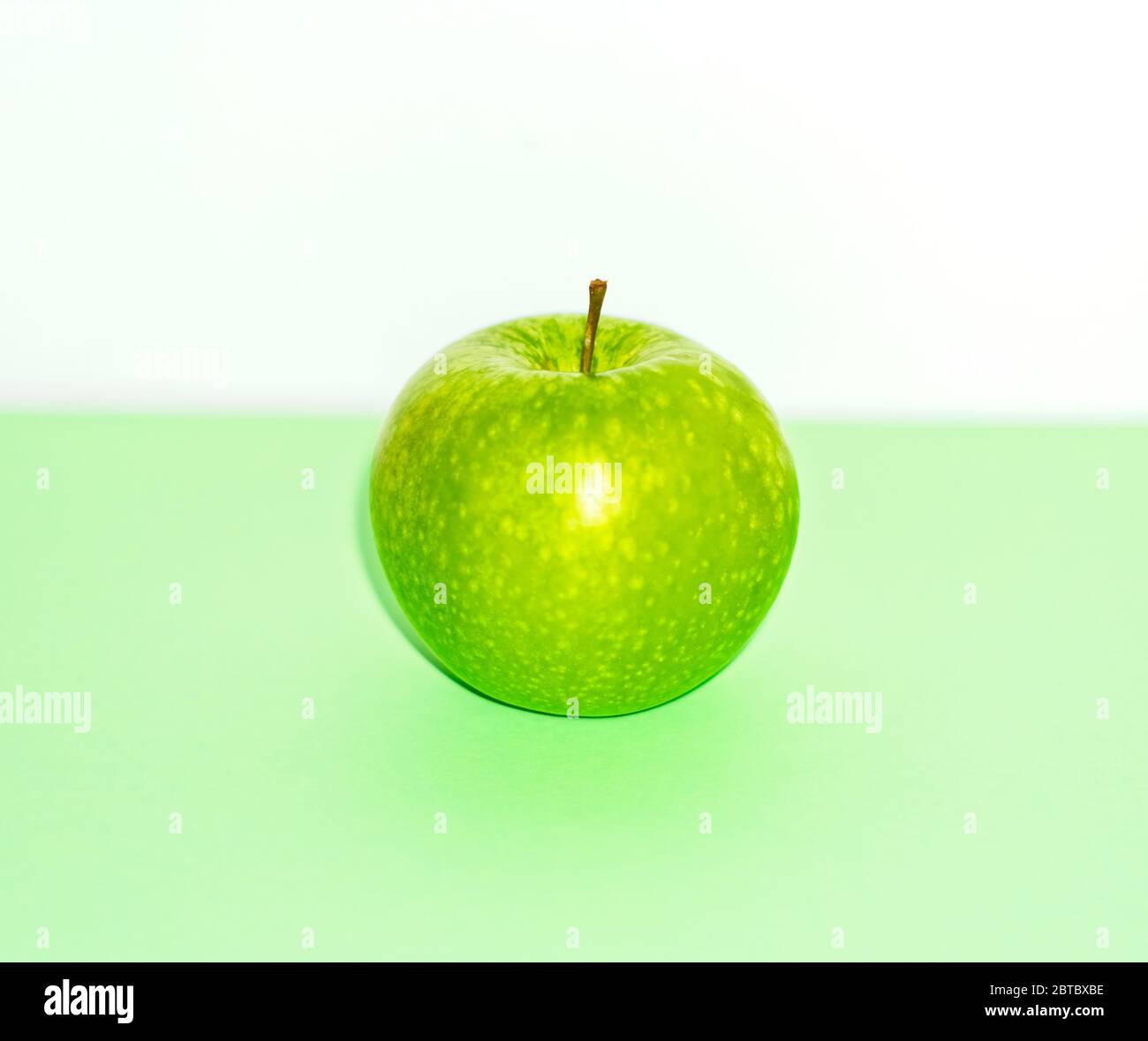 Juicy green apple seen from the side with green background Stock Photo ...