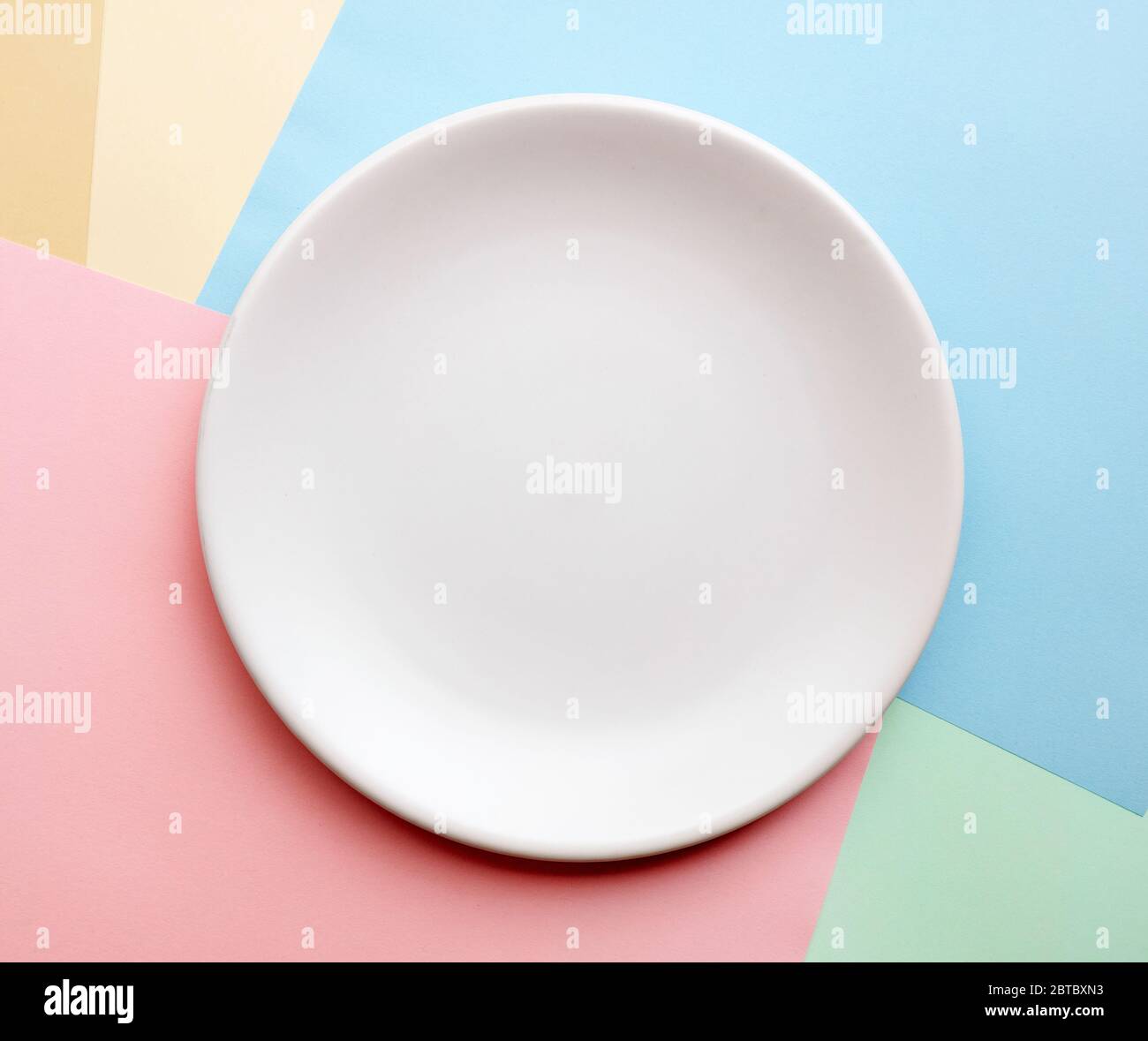 white empty plate on colorful paper background, top view Stock Photo ...