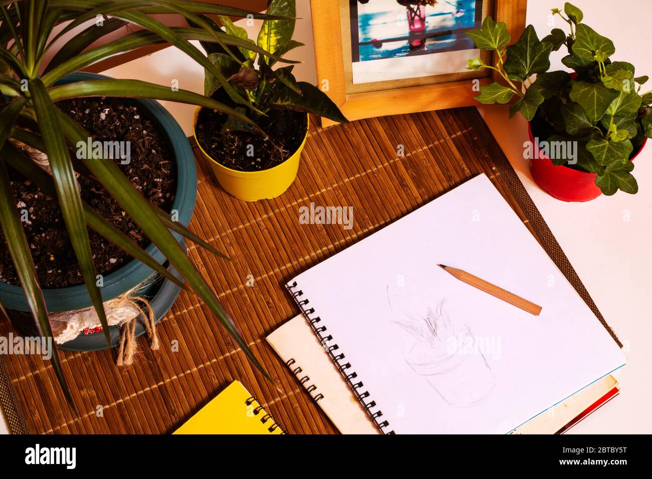 a bird eye view of small desk with notebooks and pencil in front of the ...
