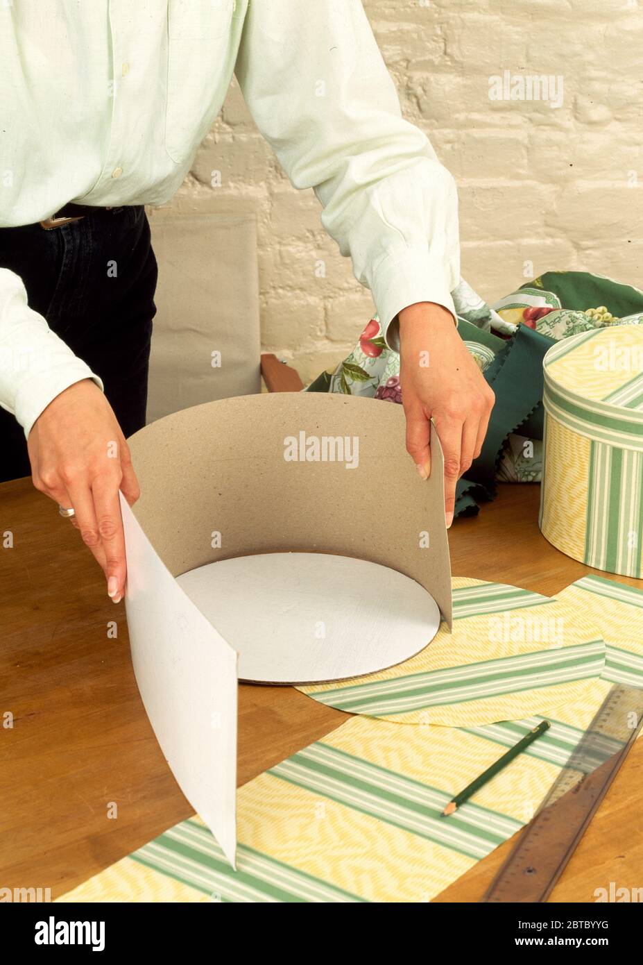 Covering a cardboard storage box with decorative paper EDITORIAL USE ...