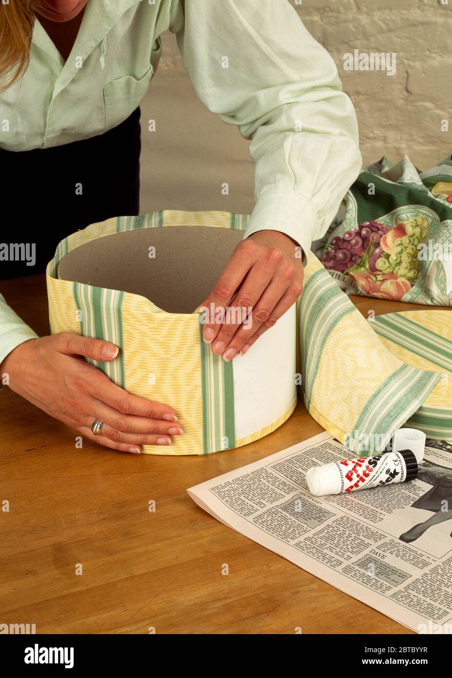 Covering a cardboard storage box with decorative paper EDITORIAL USE ...