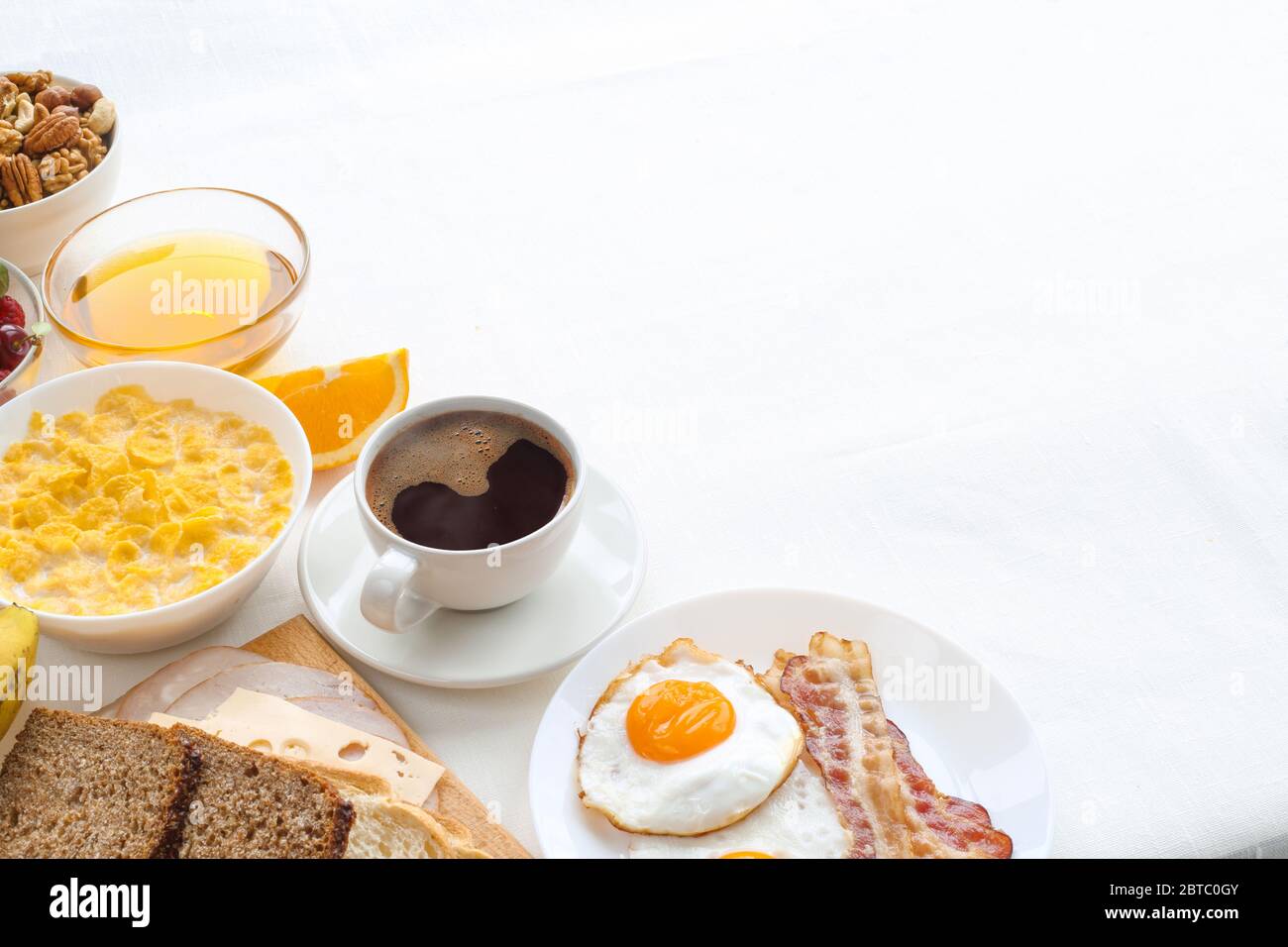 Healthy breakfast with muesli, fruits, berries, nuts, coffee, eggs ...