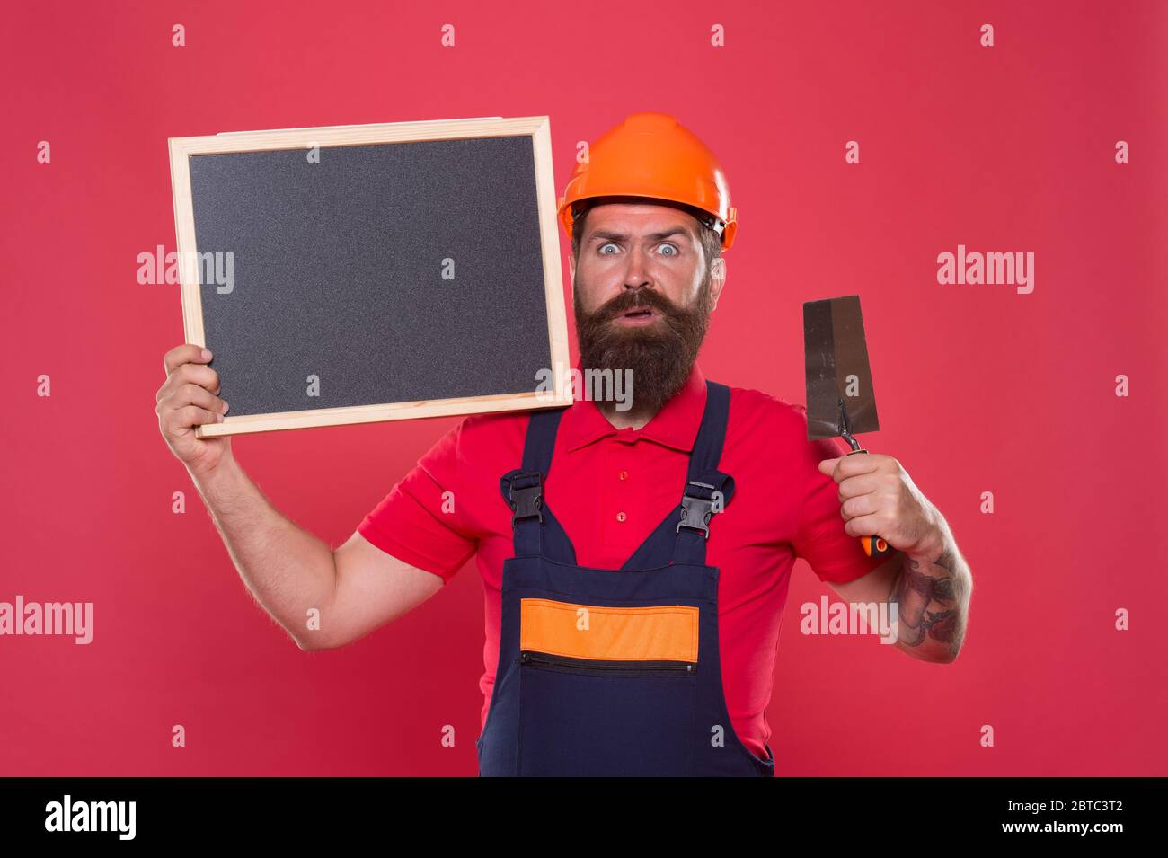 Plasterer hipster builder in hard hat hold blackboard copy space ...