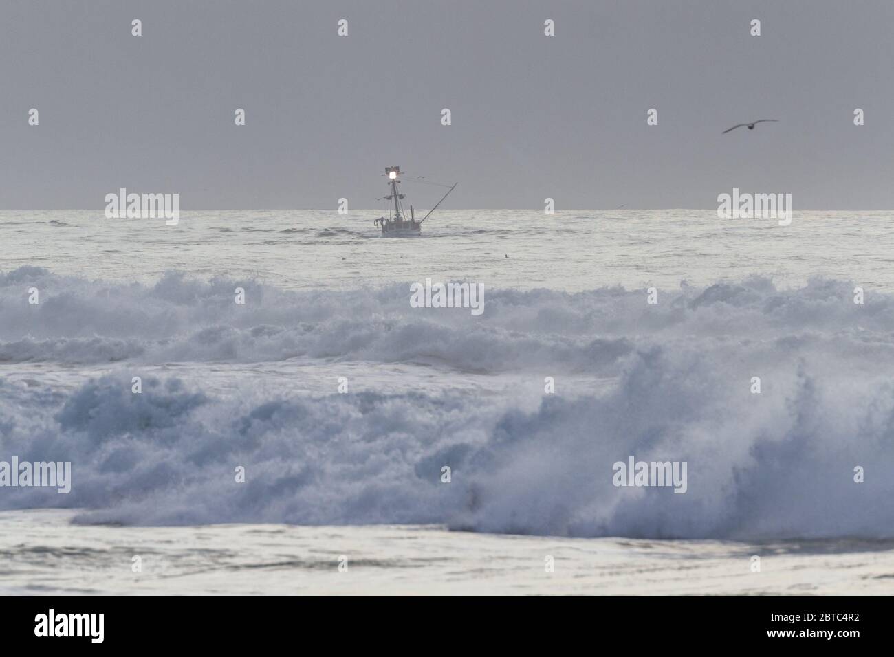 Fishing charter in the Oregon coast with rough seas as the day comes to ...
