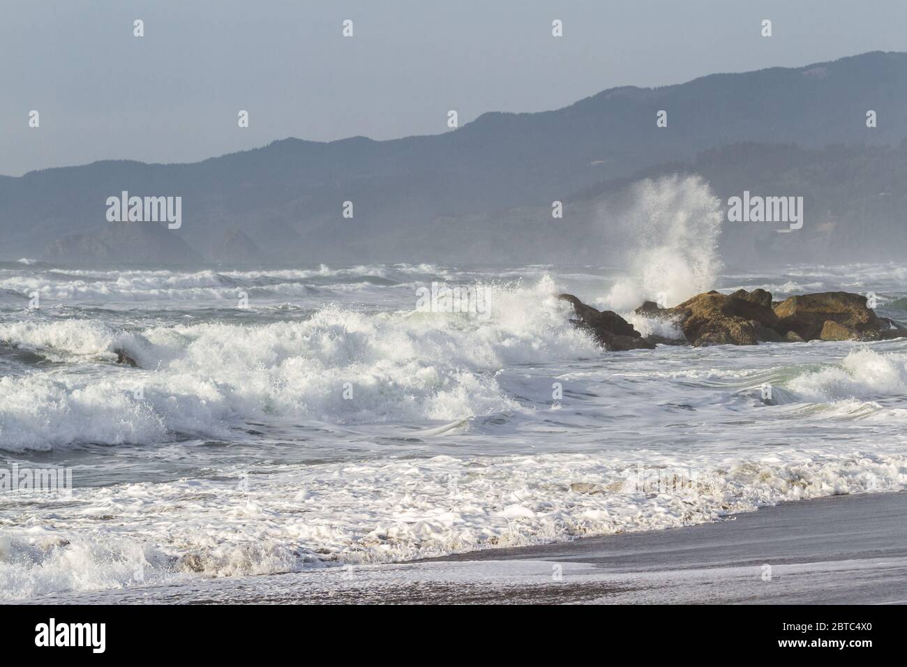 Rocky shoreline in Nesika Beach, Oregon late in the afternoon with the ...