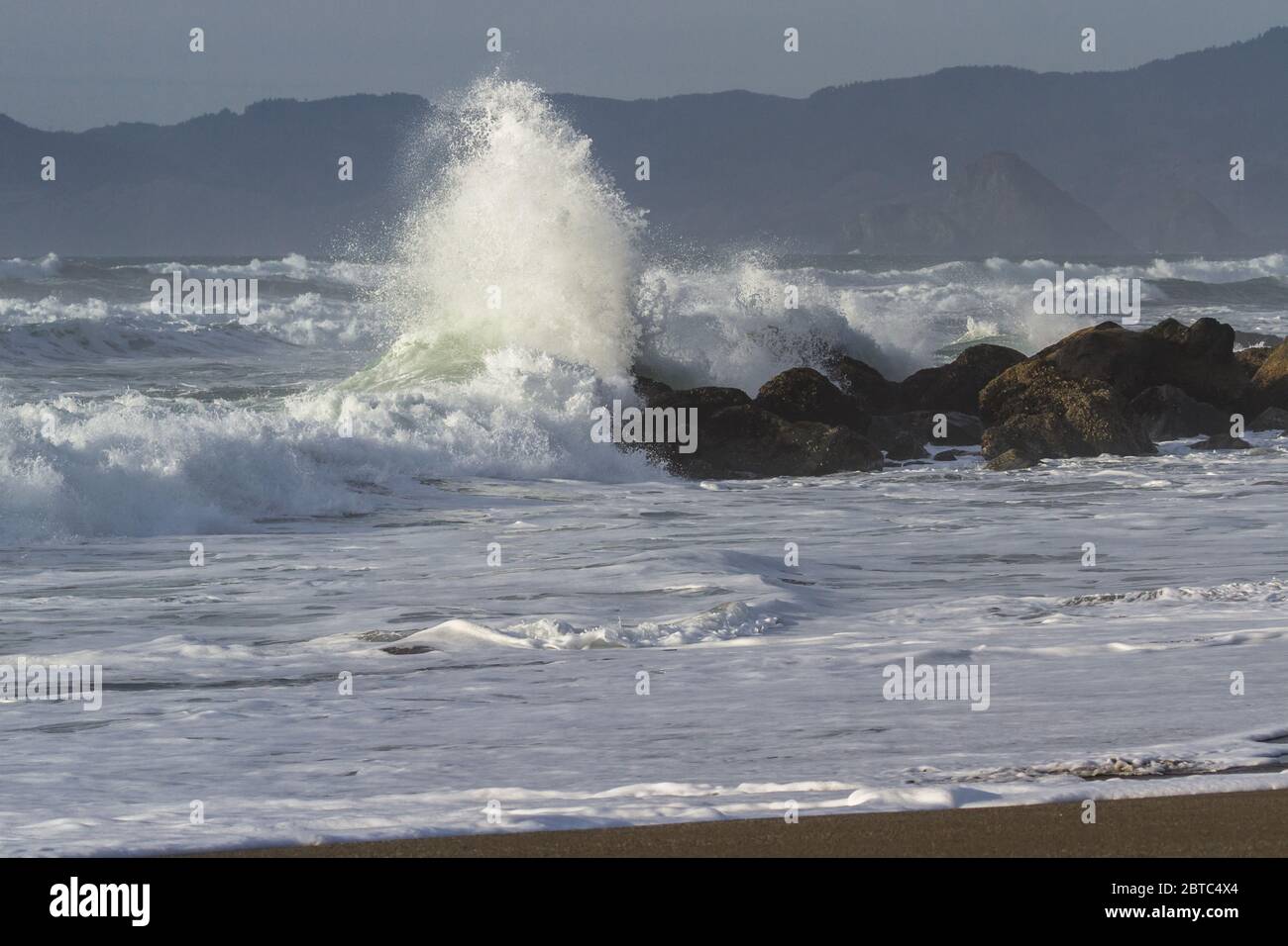 Rocky shoreline in Nesika Beach, Oregon late in the afternoon with the ...