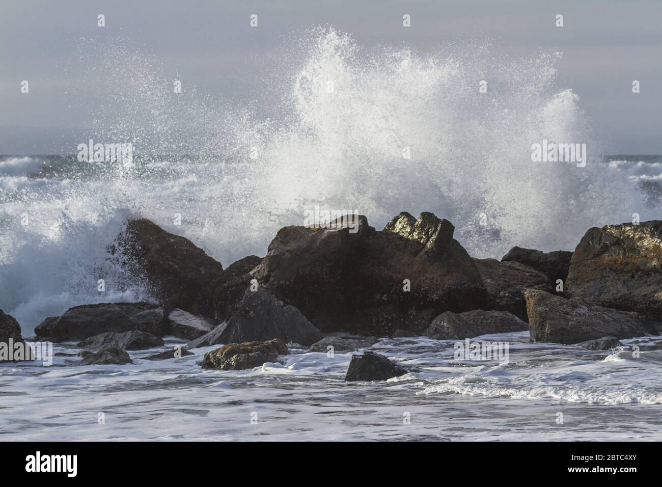 Rocky shoreline in Nesika Beach, Oregon late in the afternoon with the ...