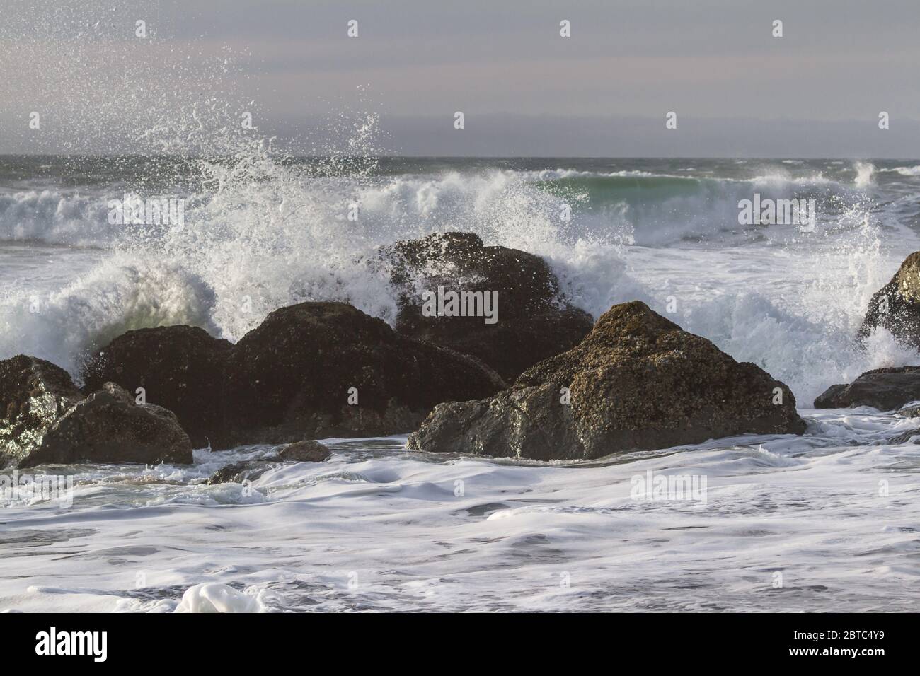 Rocky shoreline in Nesika Beach, Oregon late in the afternoon with the ...