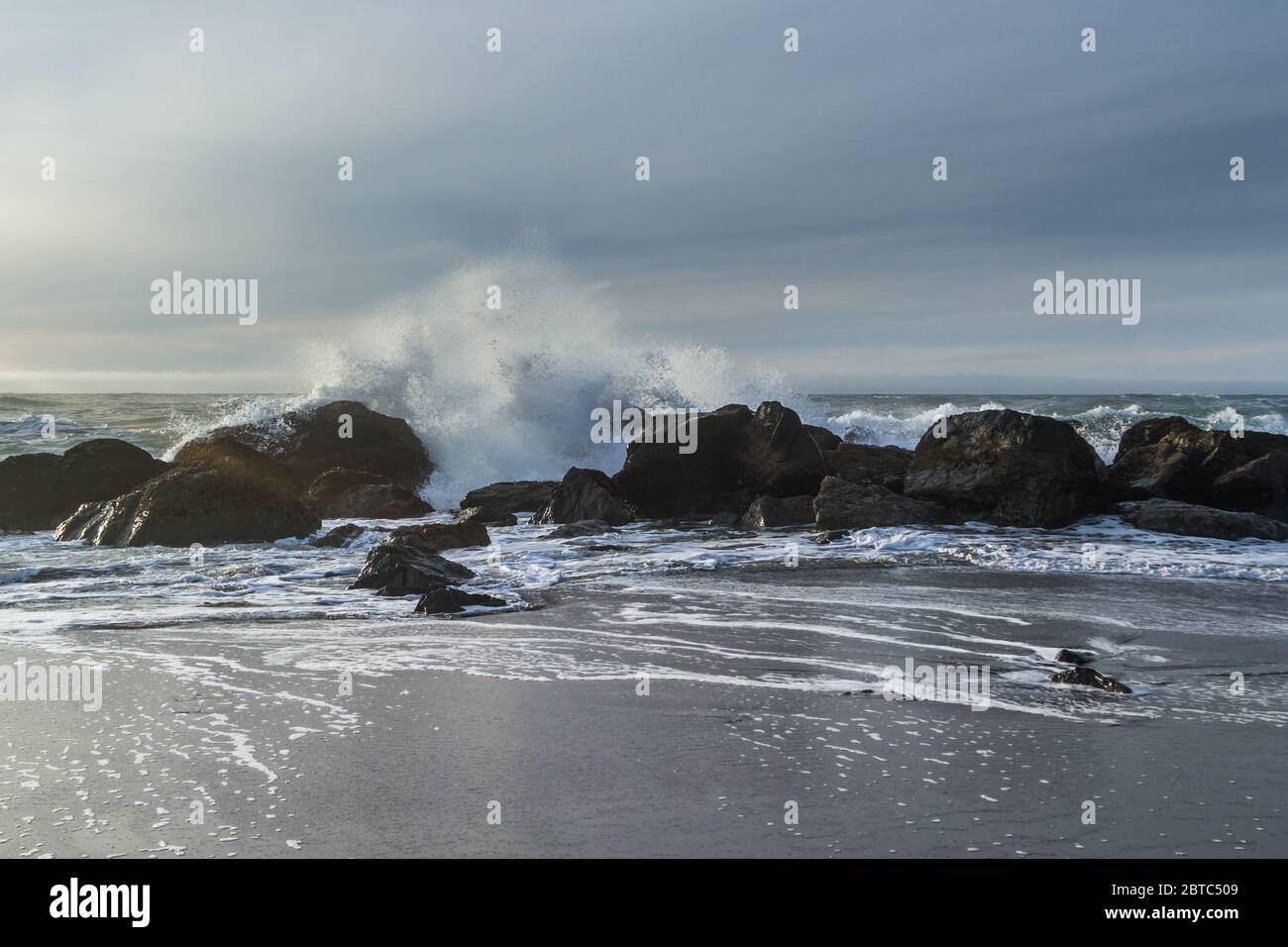 Rocky shoreline in Nesika Beach, Oregon late in the afternoon with the ...