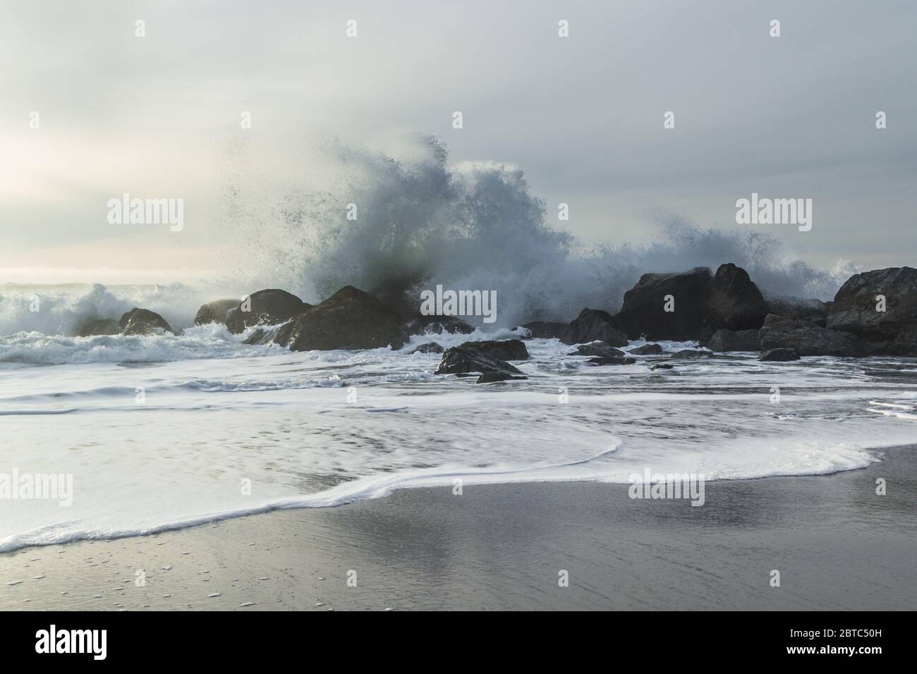 Rocky shoreline in Nesika Beach, Oregon late in the afternoon with the ...