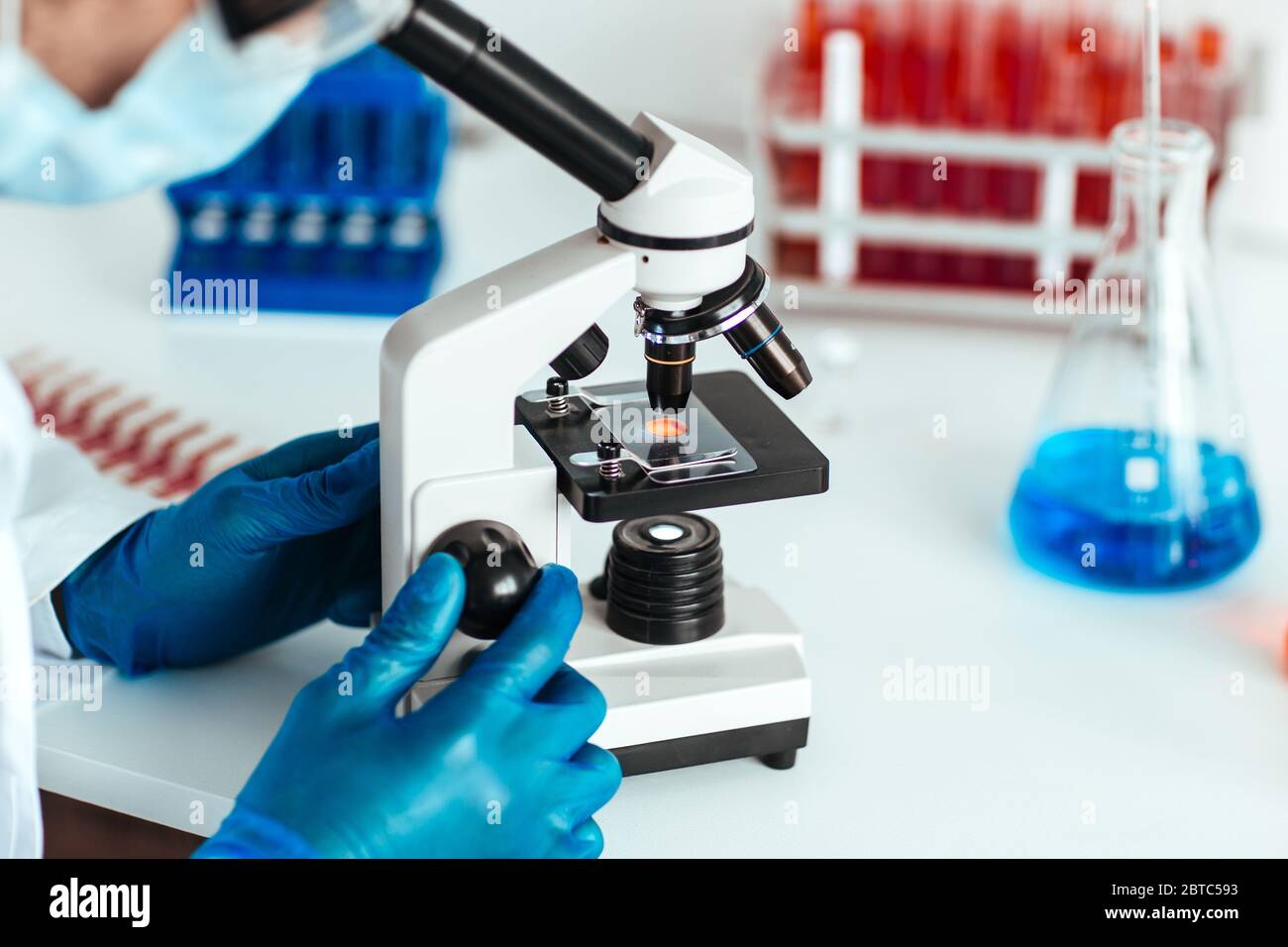 scientist looking at a drop of blood through a microscope Stock Photo ...