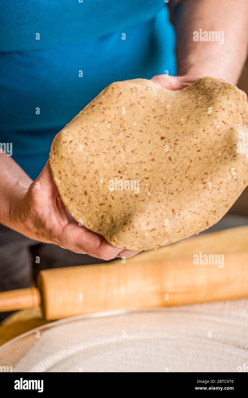 Stretching the multi-grain pizza dough on your hands to make a thin ...