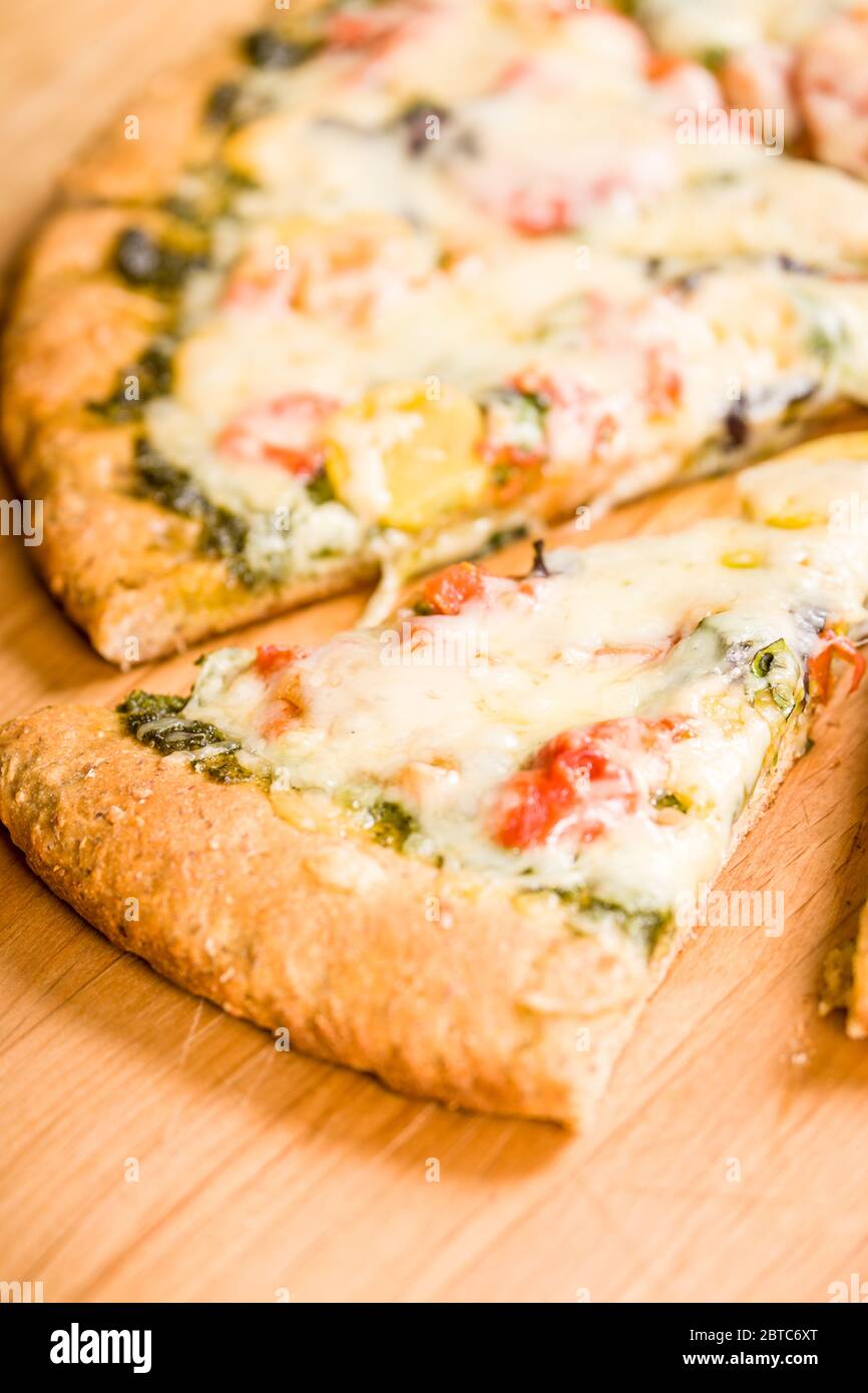 Freshly-baked, vegetarian, pesto, multi-grain, thick-crust pizza cut ...