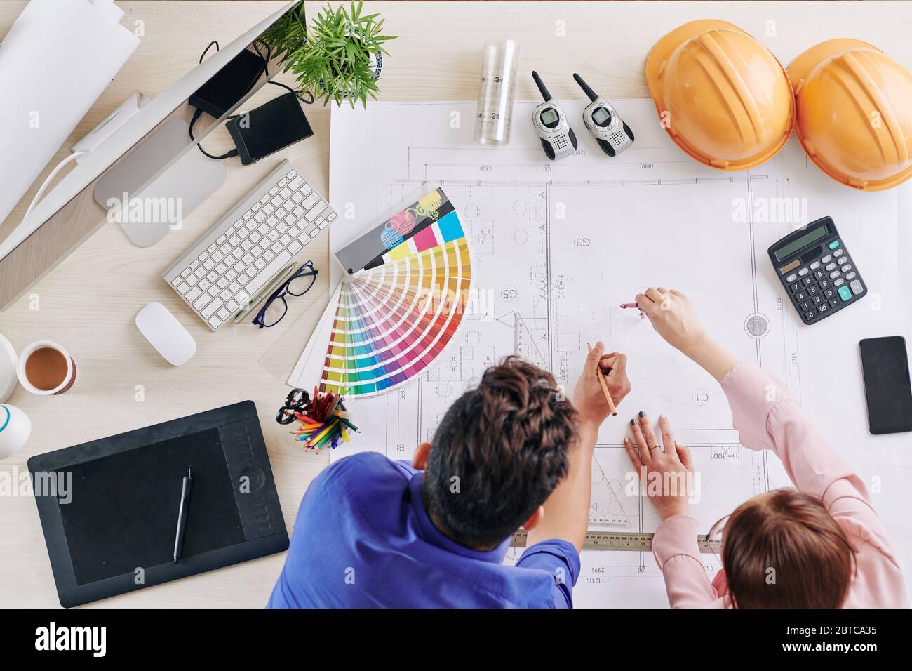 Professional architects working on blueprint of modern house, view from ...