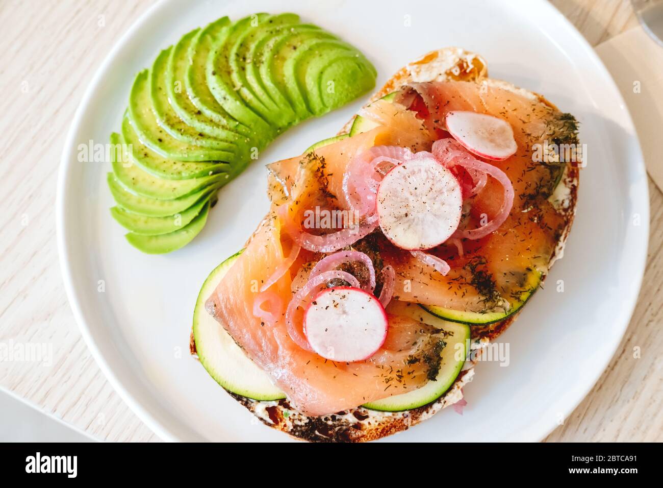 Salmon toast with avocado and vegs in the modern cafe. Fancy cafe and ...