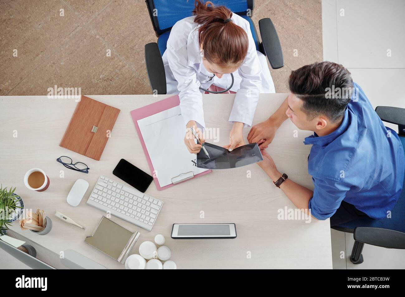 Doctor discussing chest x-ray with patient and explaining him danger of ...