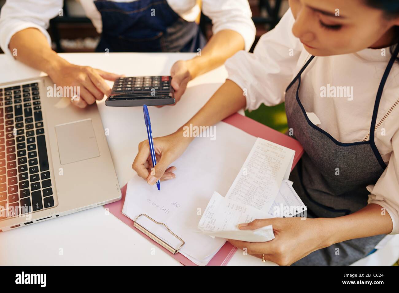 Cafe owners checking bills and receipts, taking notes and making ...