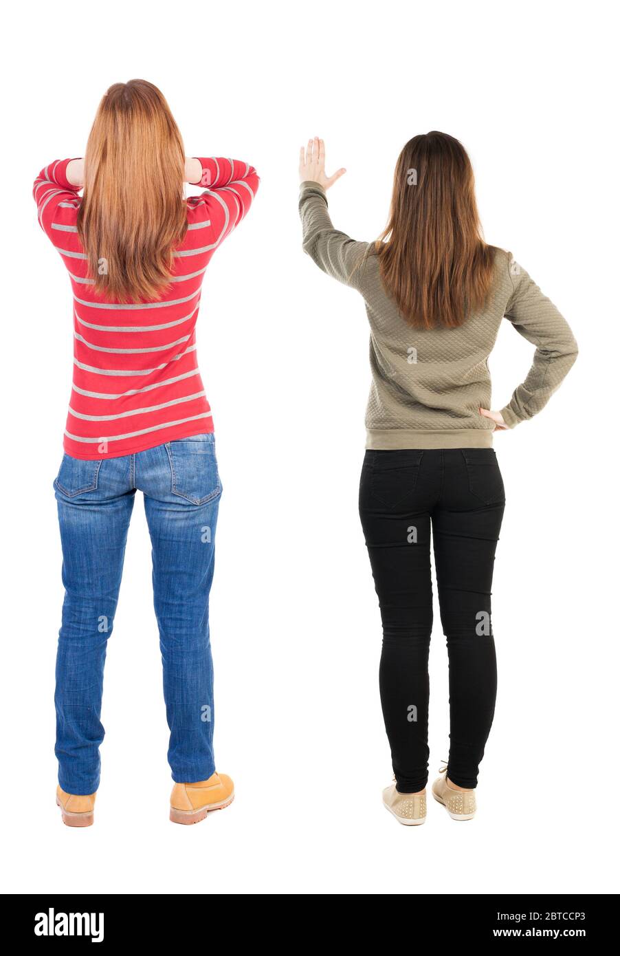 Back view of two young woman photographed on a mobile phone in sweater ...