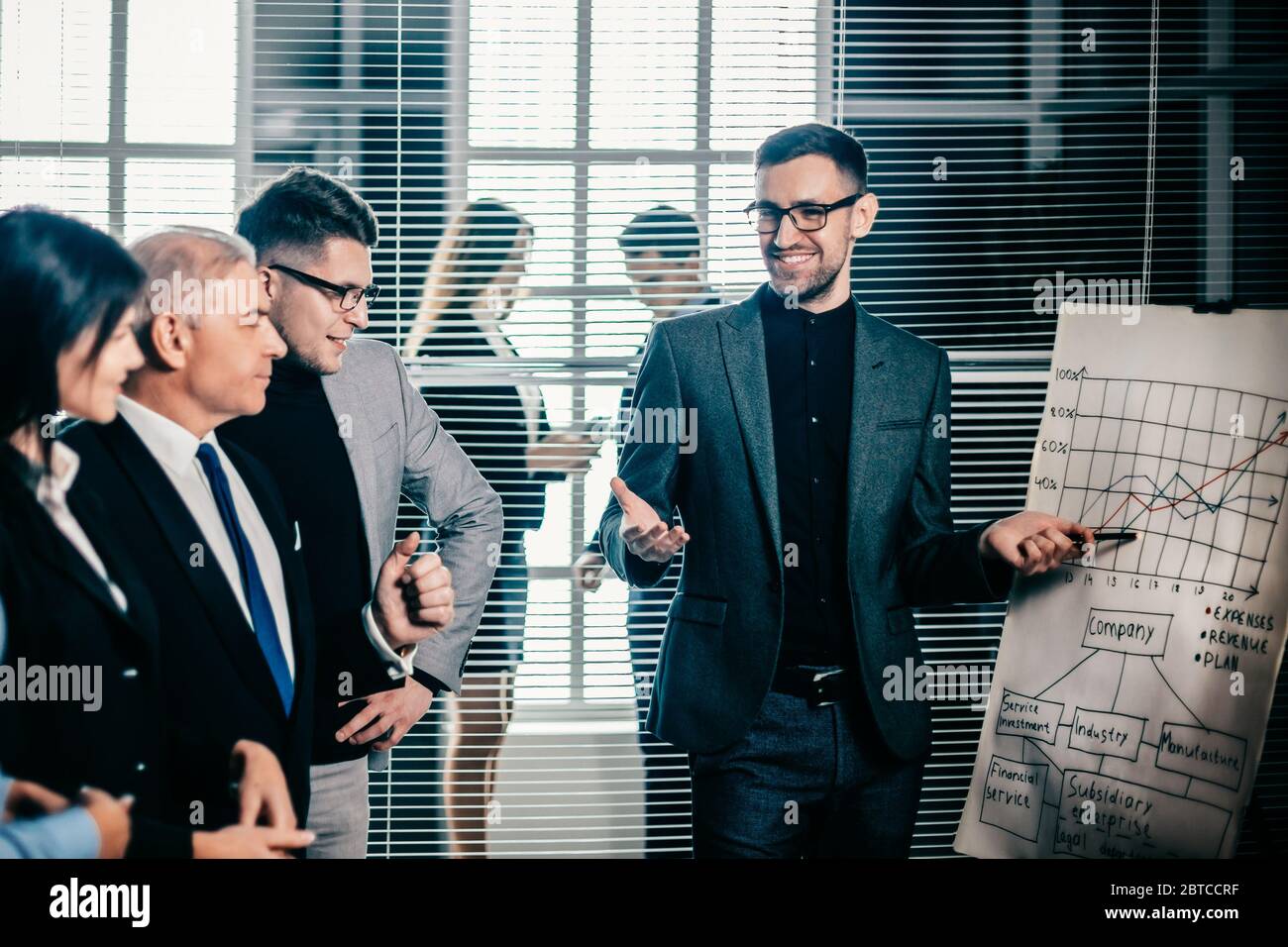 project Manager pointing to a flipchart with a schedule Stock Photo - Alamy