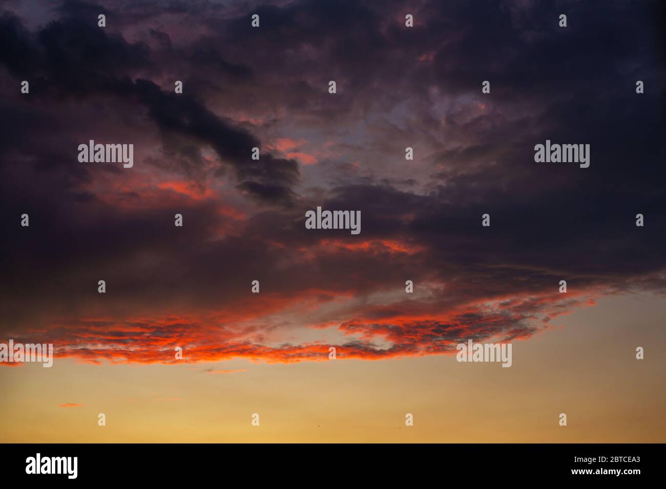 Black thunderclouds at sunset. Bright orange sunset and dark clouds ...