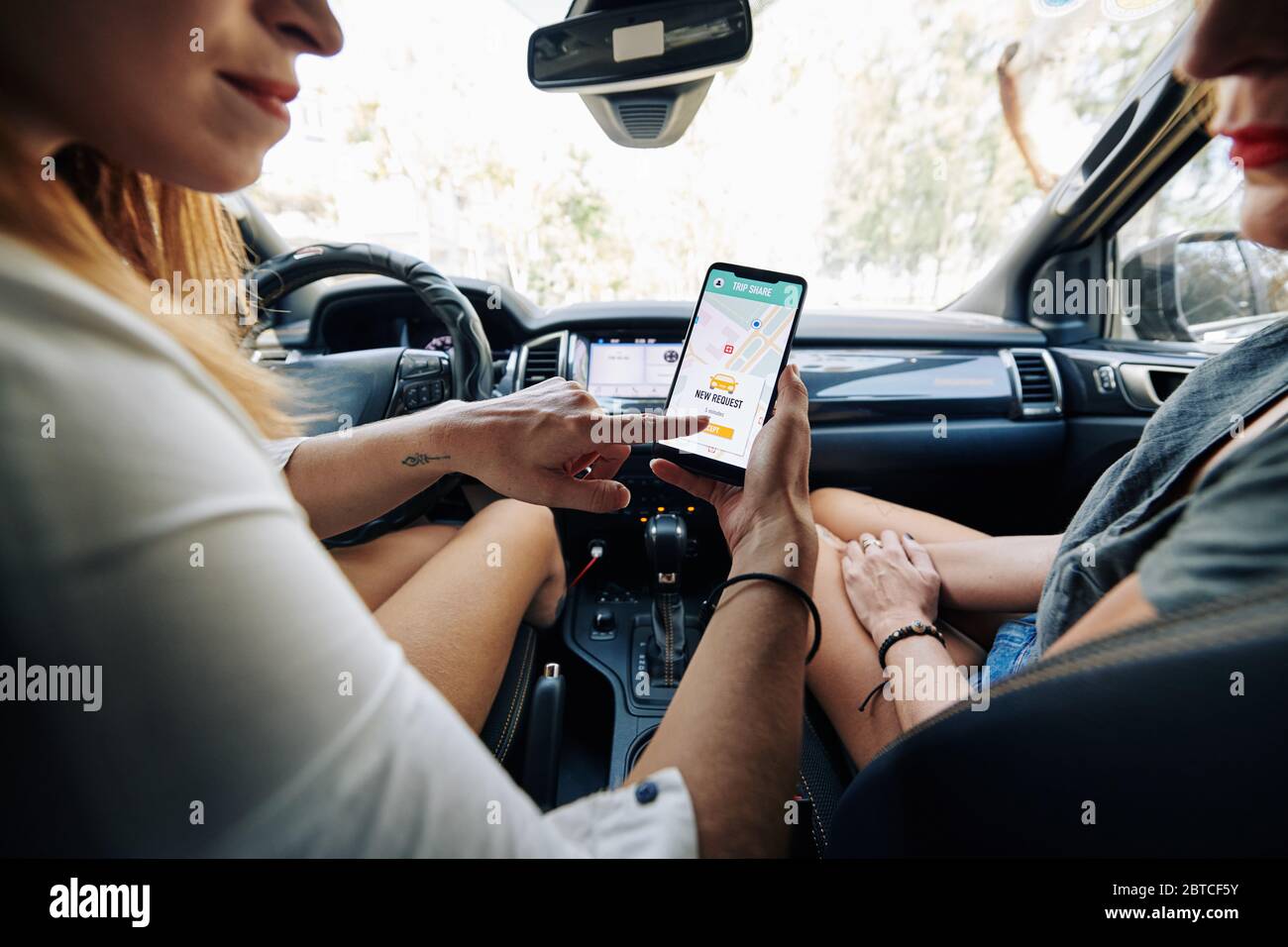 Smiling female driver greeting passenger and accepting new request in ...