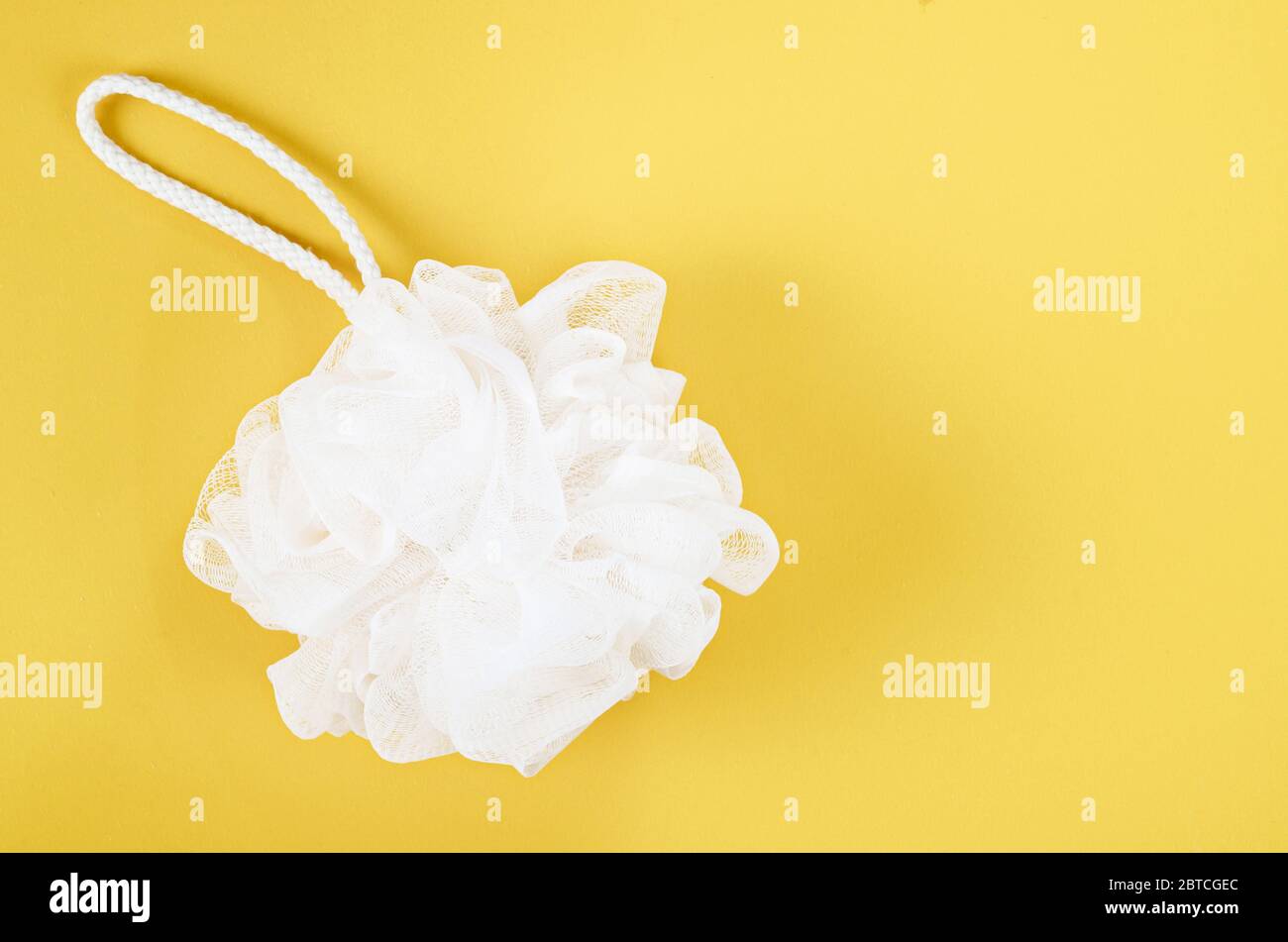 White puff Shower sponge mesh, bath body scrubber on yellow background ...