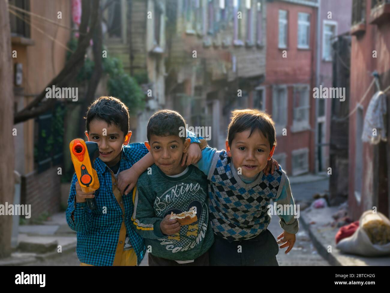 Syrian children playing with toy gun on the street in Istanbul. All the ...