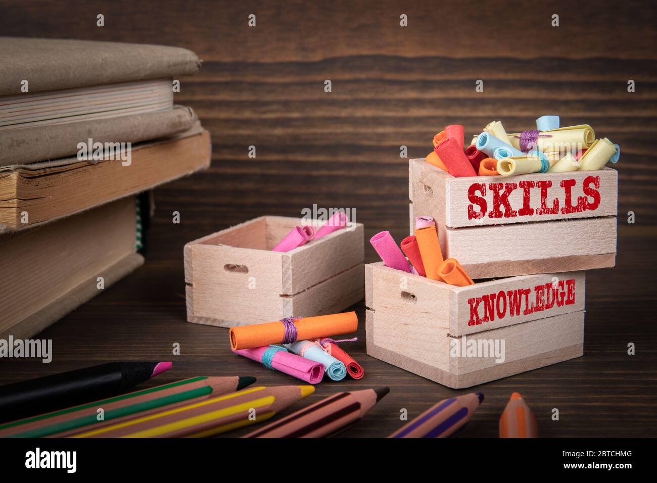 SKILLS and KNOWLEDGE concept. Colored papr scrolls in wooden boxes on ...