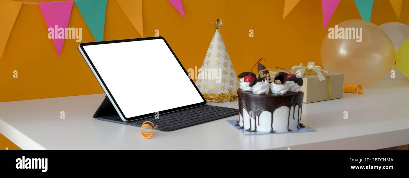 Online birthday party concept with blank screen tablet, cake, party hat ...