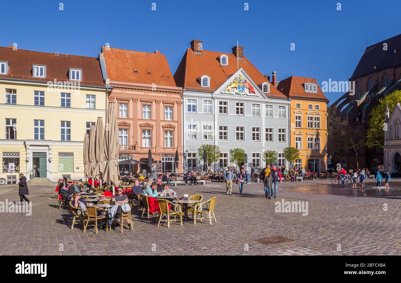 People enjoying the sun on the market square of Stralsund, Germany ...