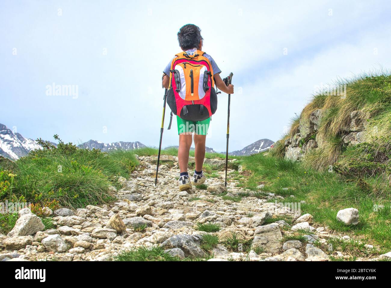 Little boy walks on mountain trail during an excursion. with the ...