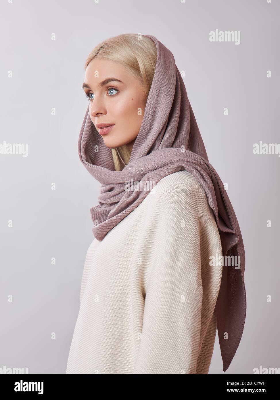 European Muslim woman with a blonde hair in a headscarf shawl dressed ...