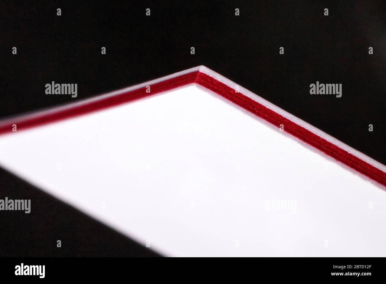 White and red three-ply thick stock business cards, floating on a black ...