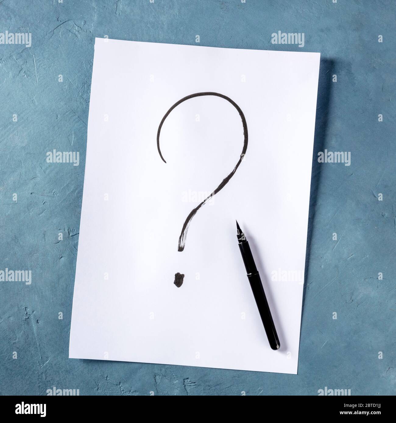 Question mark, written in ink on a piece of standard office paper ...