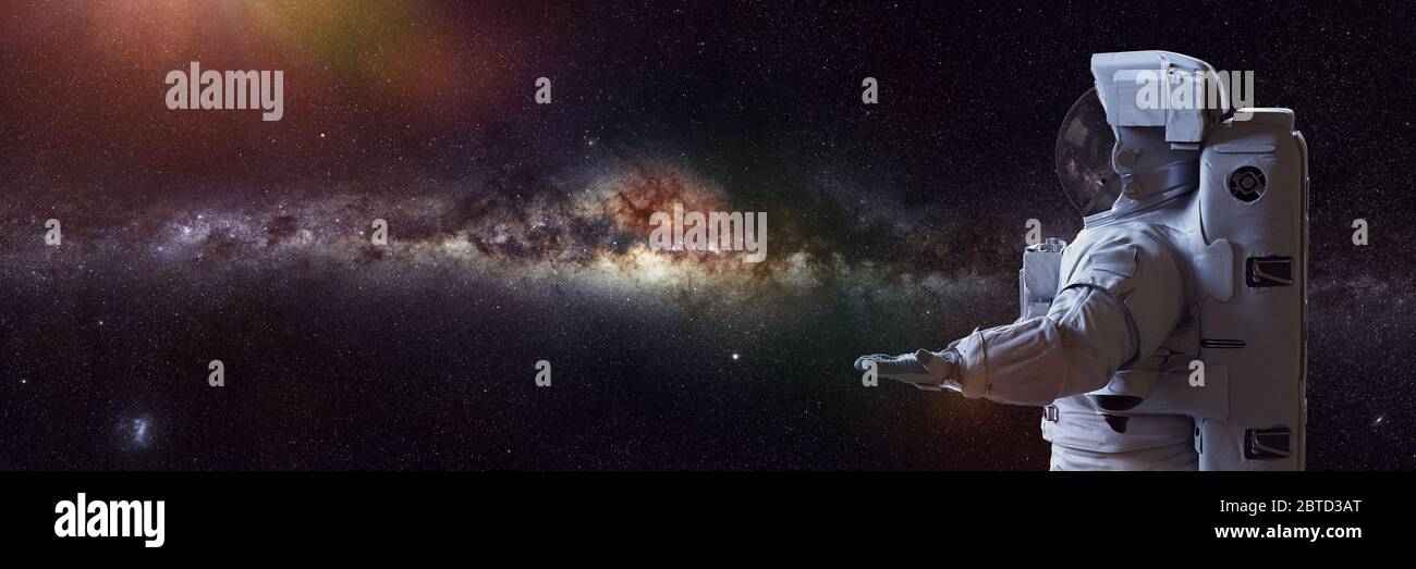 astronaut presenting an empty space in front of the Milky Way galaxy ...