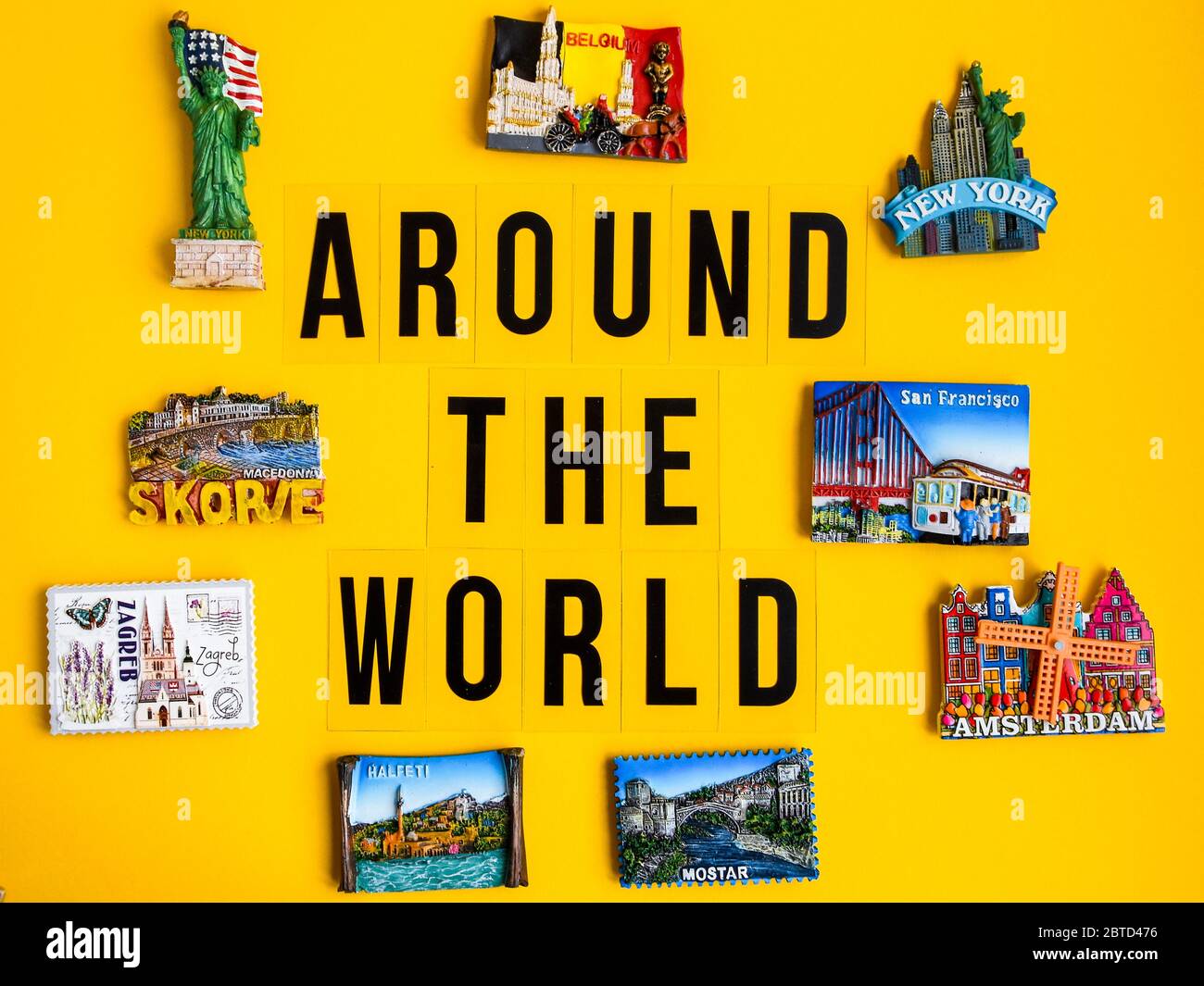 Text Around the world Magnets from different countries on yellow ...