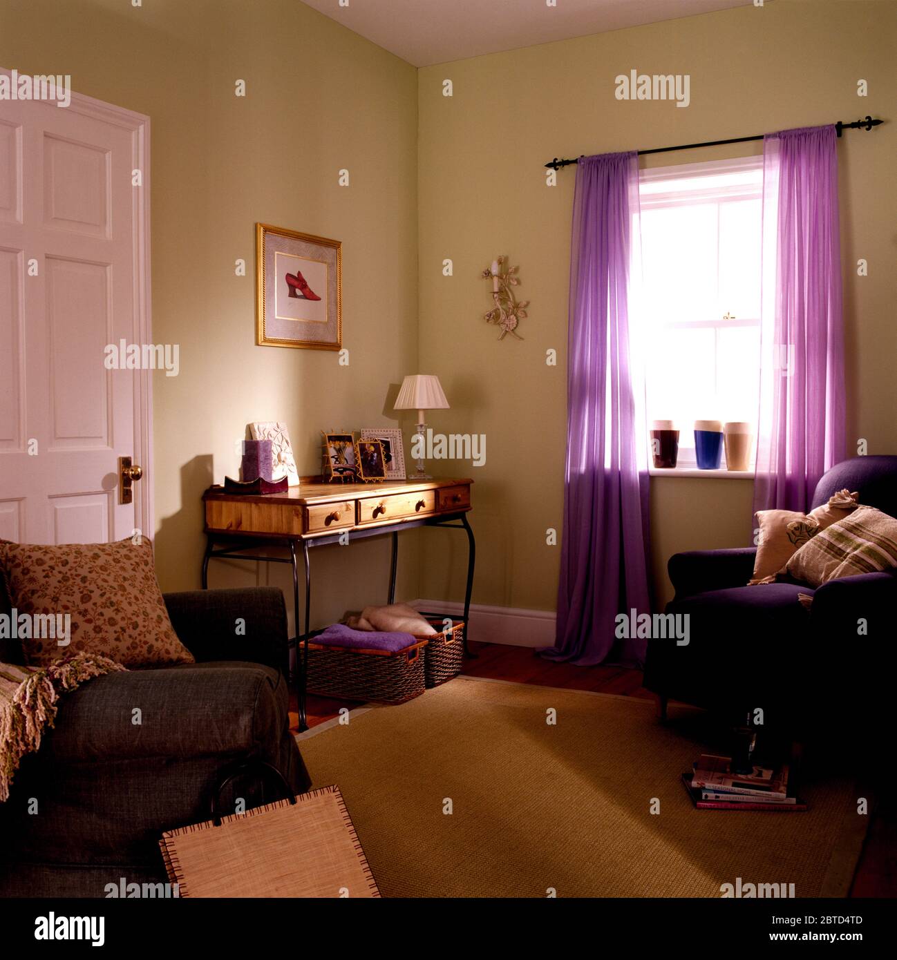 Mauve drapes in economy style living room Stock Photo - Alamy