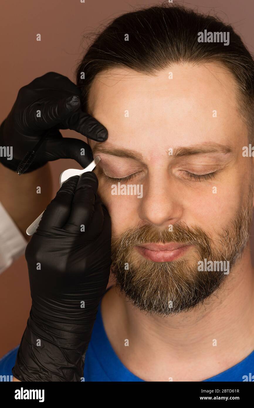 Professional barber doing threading procedure and correcting shape of ...