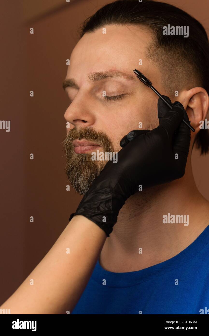 Correction shape of man eyebrow. Combing eyebrows and giving direction ...