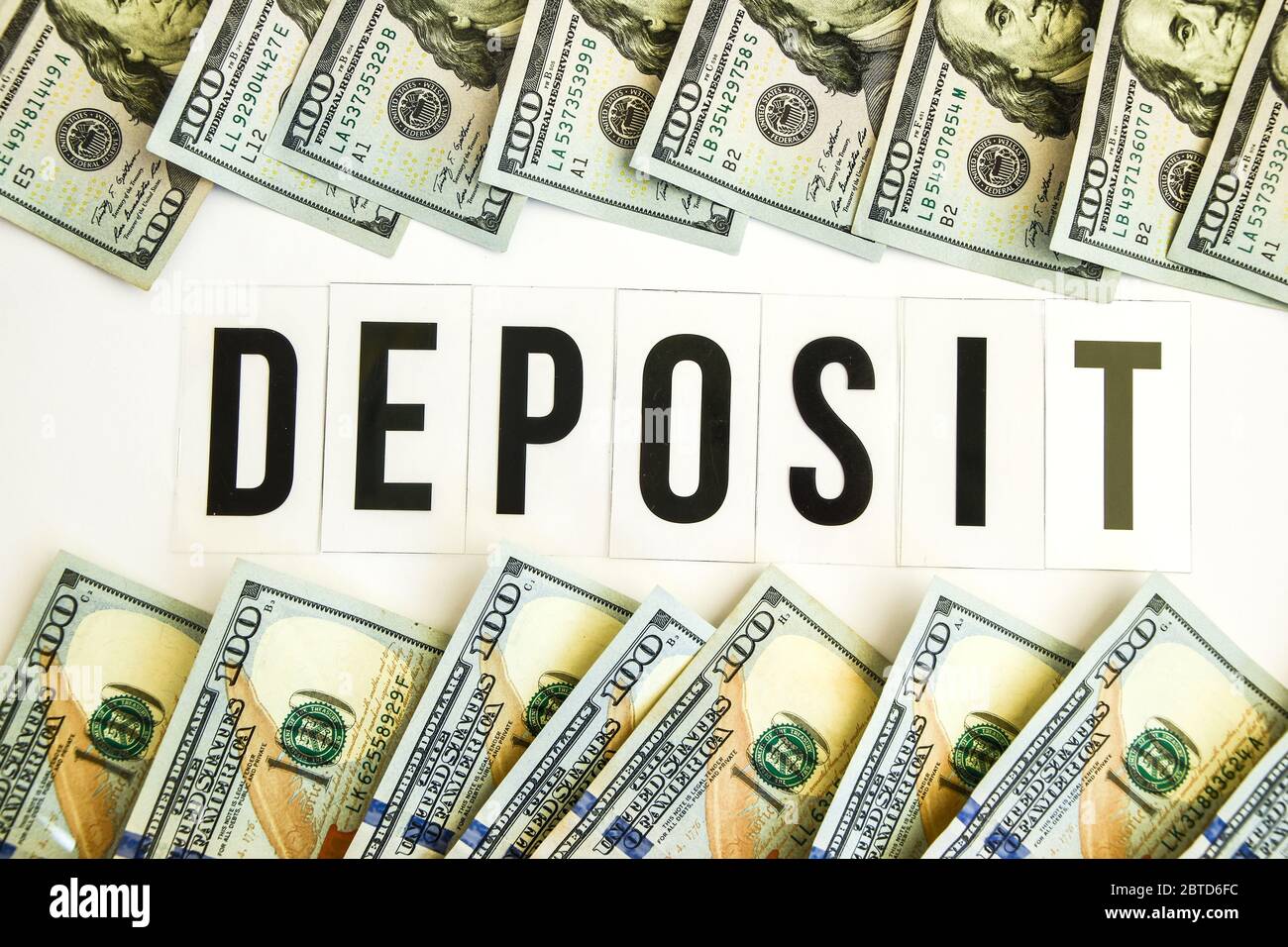DEPOSIT word written on white table. Copy space with one hundred dollar ...