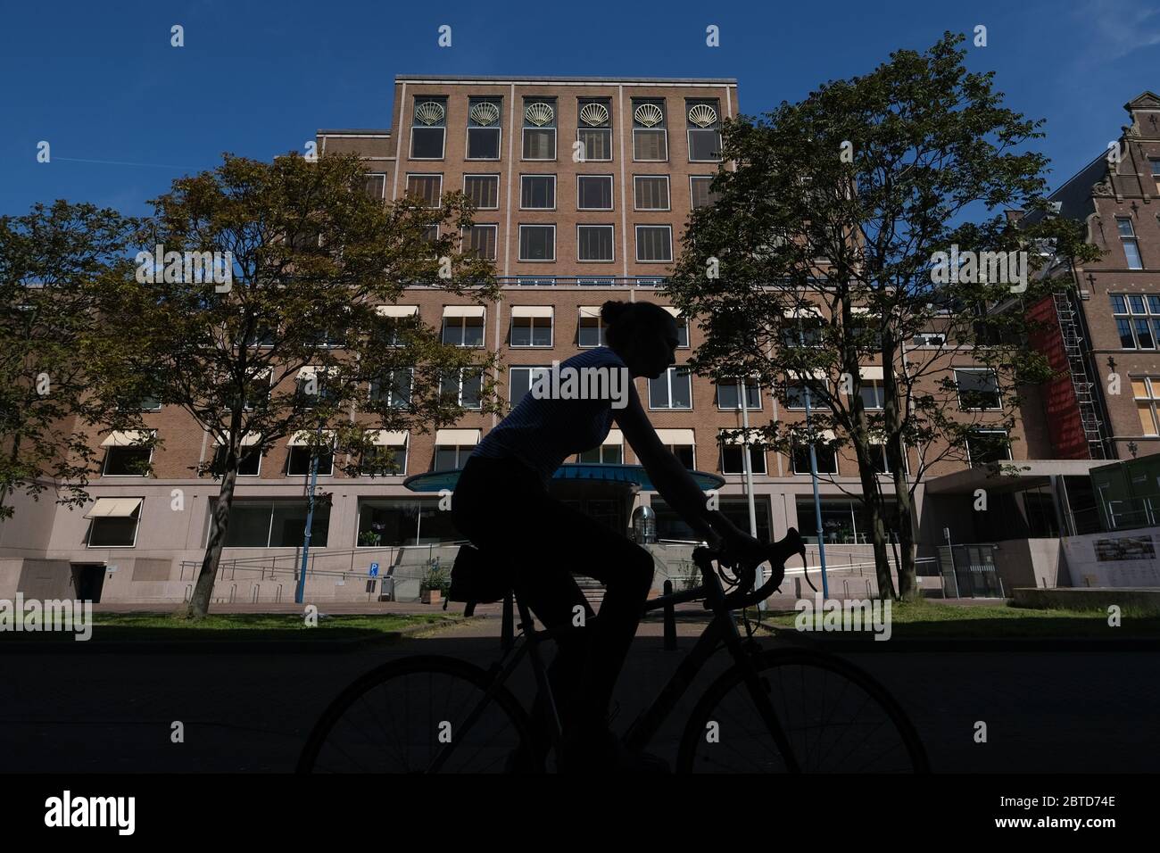 A woman cycles past Royal Dutch Shell Plc headquarters building on May ...