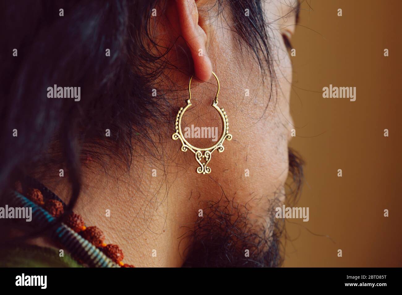 Detail of male head wearing oriental Indian style brass earring Stock ...
