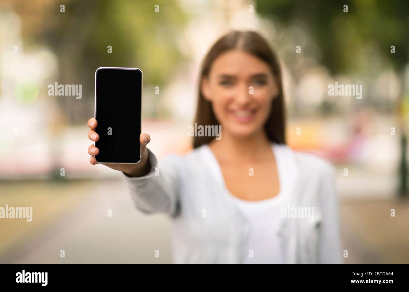 Girl Showing Smartphone Empty Screen To Camera Standing Outdoor Stock ...