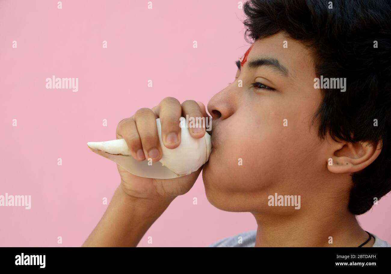 Child blowing the conch shell Stock Photo - Alamy